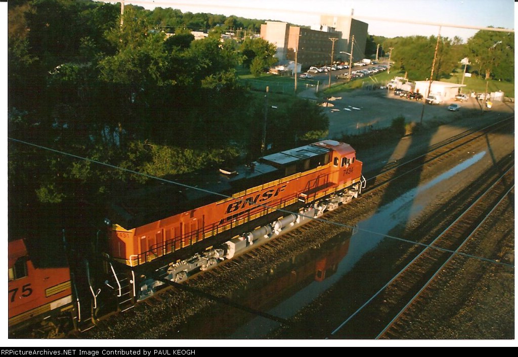 BNSF 7434 emerges from underneath the 26th St. Bridge over the BNSF Argentine yard on her maiden ...